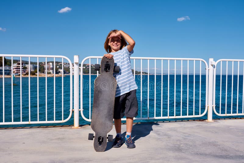 Boy Standing with a Longboard on a Pier at Sunny Day Stock Photo ...