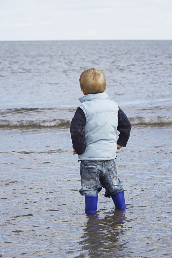 Boy Standing in Ocean stock image. Image of relaxation - 33892801