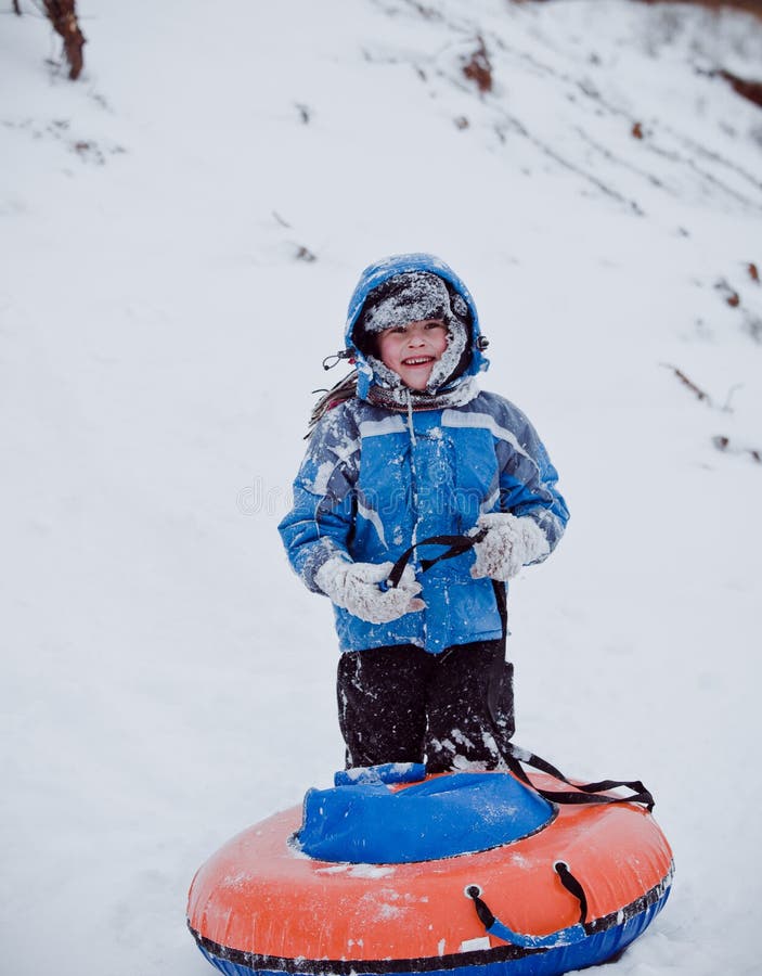 The Boy Standing in the Snow and Keeps the Tubing Stock Photo - Image ...