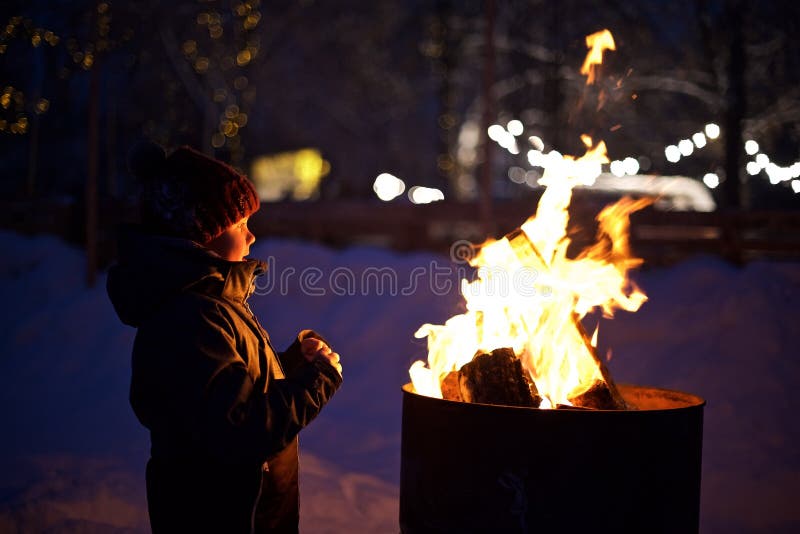 A Boy in the Winter Cold Night Park by the Fire Stock Photo - Image of ...