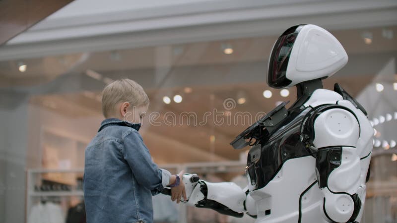 The Boy Stretches Out His Hand To the Robot for a Handshake. Stock ...