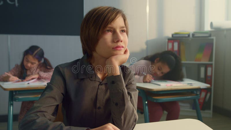 Boy Studying in Classroom with Classmates. Male Student Boring during ...