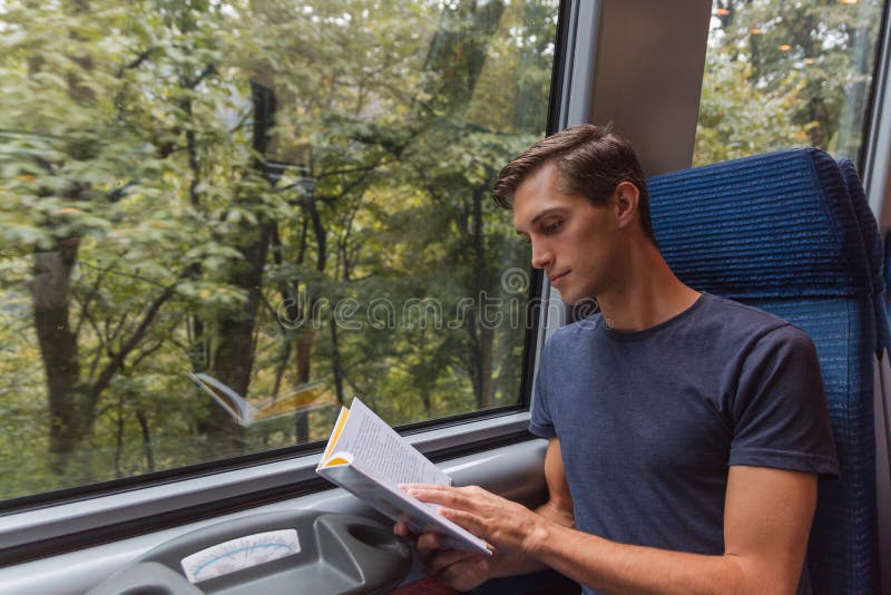 Young Handsome Man Reading a Book while Travelling by Train Stock Image ...