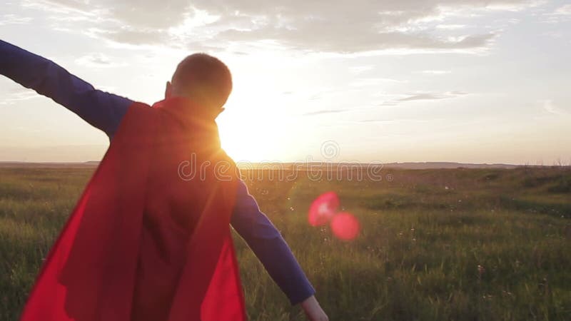 Video: Boy superhero in a field at sunset, Superhero boy running on the ...