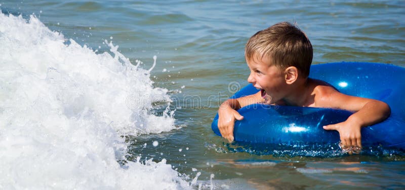 Boy in a Swim Ring Against Waves Stock Image - Image of ocean, hair ...