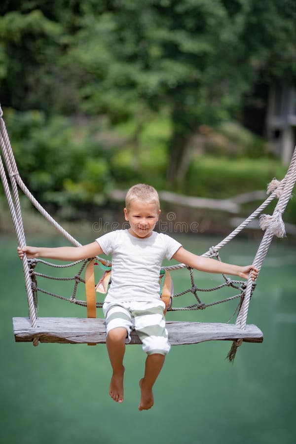 Boy Swinging on a Swing Over the River Stock Image - Image of beautiful ...