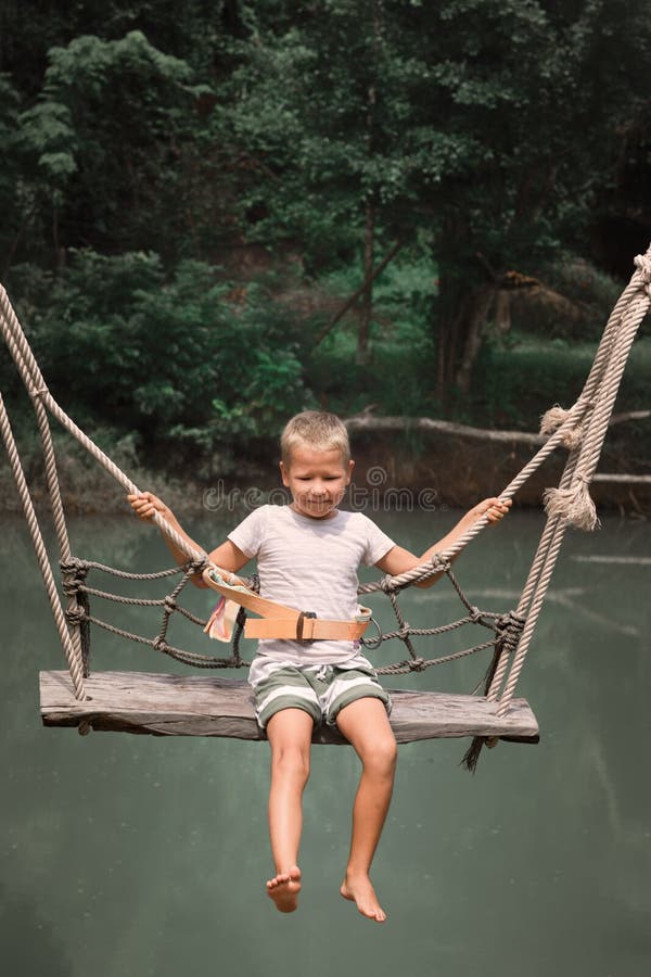 Boy Swinging on a Swing Over the River Stock Image - Image of beautiful ...