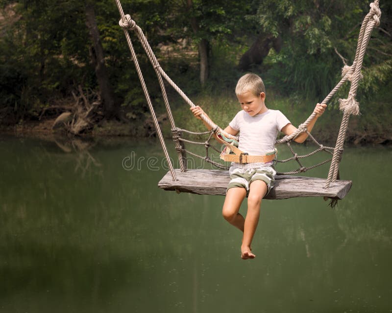 Boy Swinging on a Swing Over the River Stock Photo - Image of motion ...