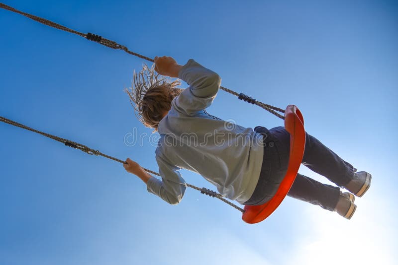 Boy Swinging Very High, Blue Sky in Background Stock Photo - Image of ...