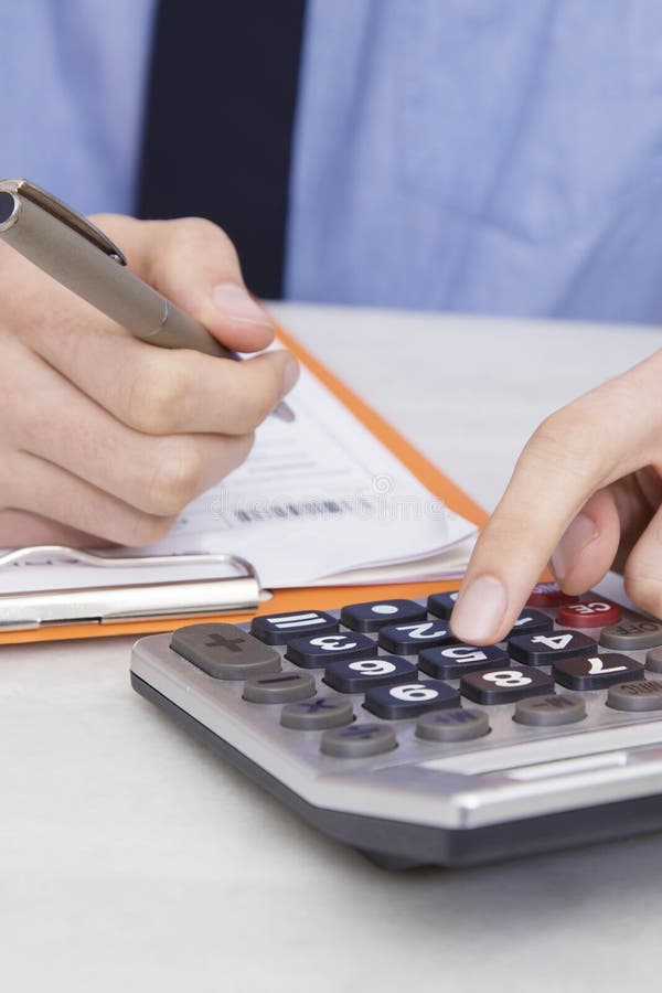 On the Table is a Calculator, a Pen and a Notebook with a Bookmark on ...