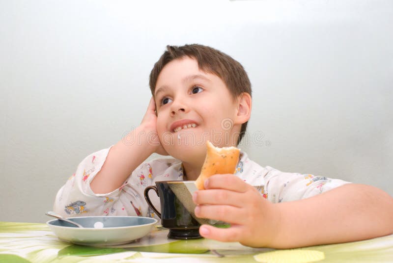 Boy at table eating stock image. Image of young, roll - 5446893