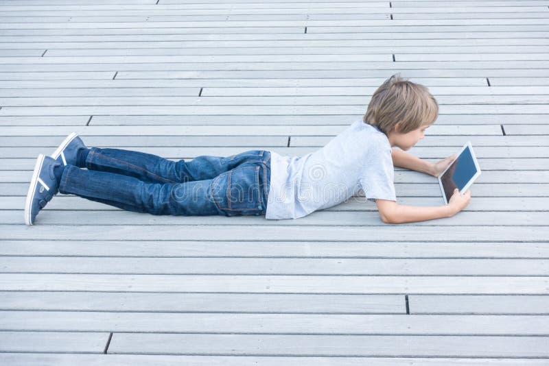 Boy with Tablet Computer Lying on Summer Terrace Stock Photo - Image of ...