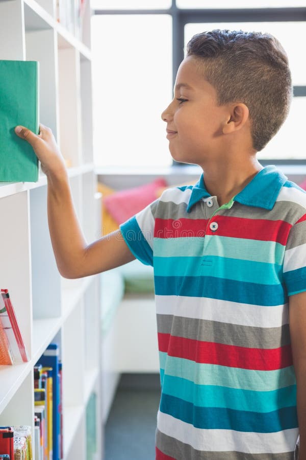 Boy Taking a Book from Bookshelf in Library Stock Image - Image of ...