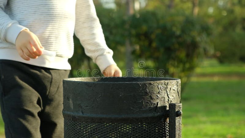 A Boy Throws Garbage in a Trash Can in the Park. Stock Video - Video of ...