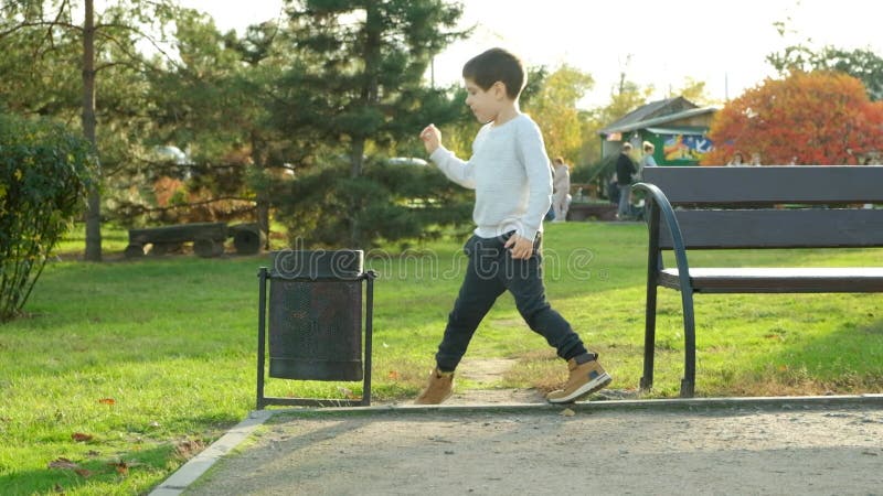 A Boy Throws Garbage in a Trash Can in the Park. Stock Video - Video of ...