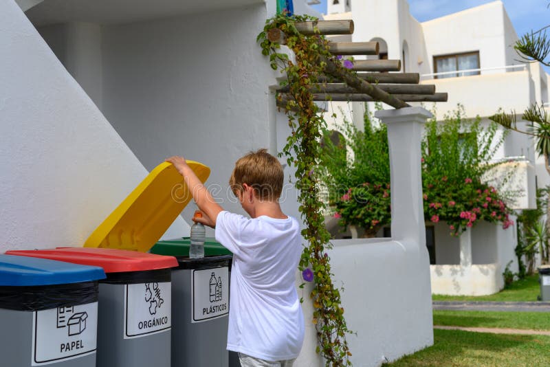 Boy Throws a Plastic Bottle into the Yellow Container for Recycling ...