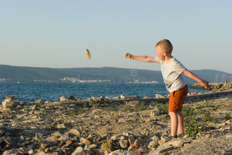 Boy in red throwing stone stock photo. Image of active - 14345762
