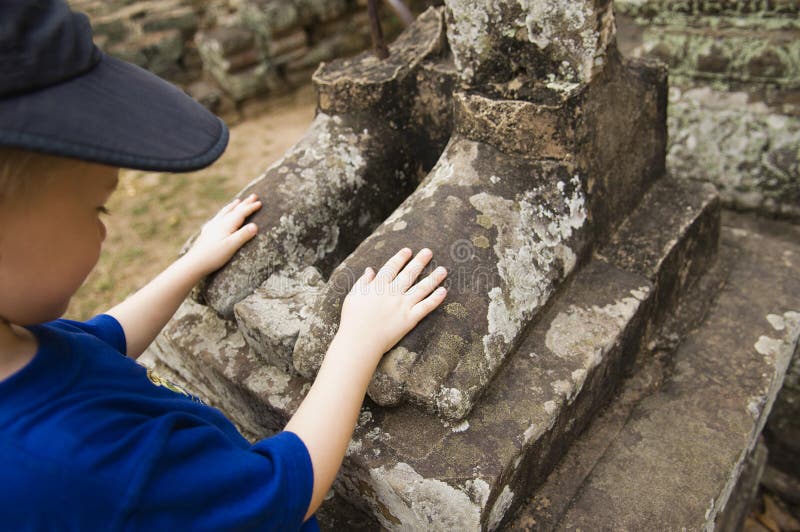 Boy Touching Feet of Ancient Statue Stock Image - Image of people, foot ...