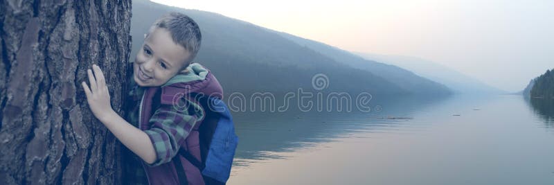 Boy Touching Tree in Front of Lake Stock Photo - Image of innocence ...