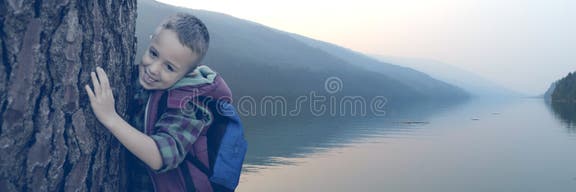 Boy Touching Tree in Front of Lake Stock Photo - Image of innocence ...