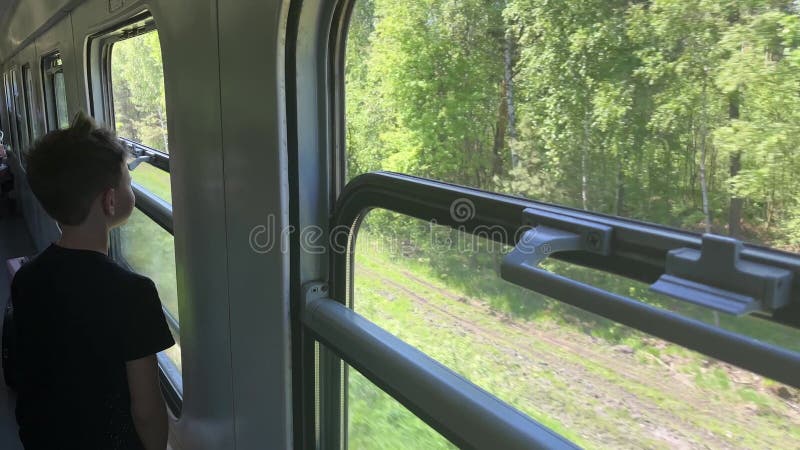 A Boy on a Train. Rear View of a Boy Riding a Train and Looking Out the ...
