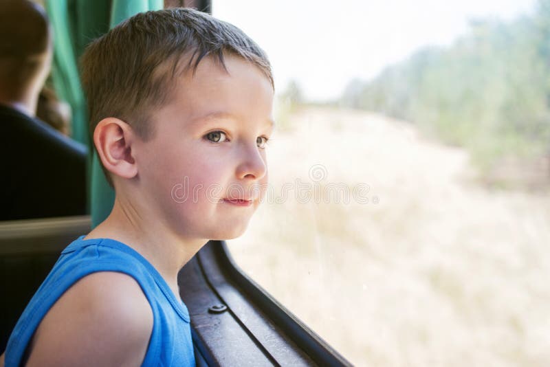 The Boy is Traveling by Train and Looking through the Window, Watching ...