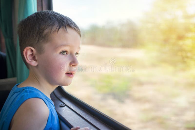The Boy is Traveling by Train and Looks Out the Window, Watching the ...