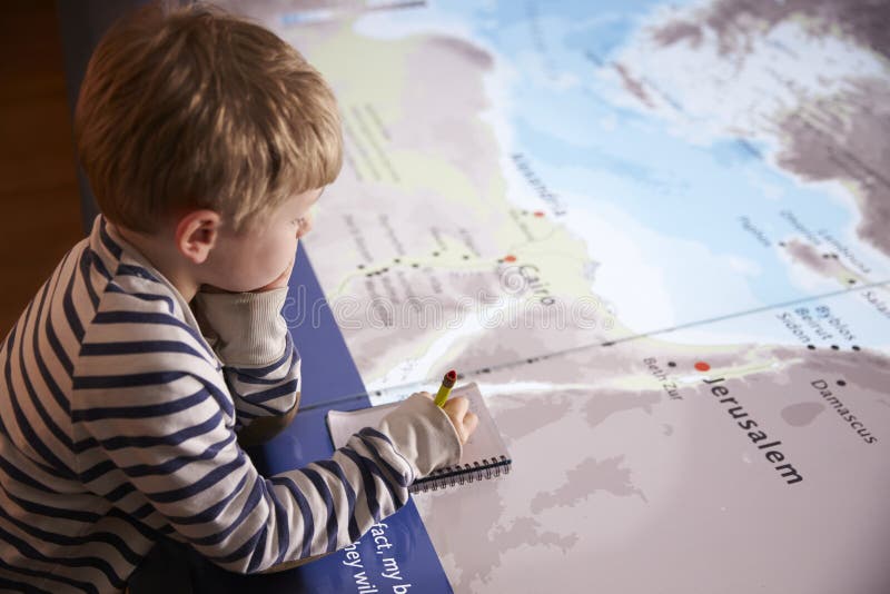 Boy on Trip To Museum Looking at Map and Writing in Notebook Editorial ...