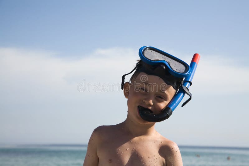 A Boy in an Underwater Mask and a Breathing Tube, Standing on the Beach ...