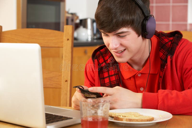 Boy Using Electronics Whilst Eating Breakfast Stock Image - Image of ...