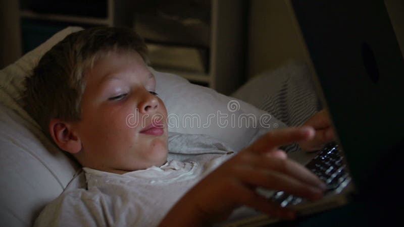 Boy Using Laptop Computer in Bed at Night Stock Video - Video of ...