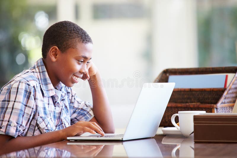 Boy Using Laptop on Desk at Home Stock Photo - Image of happy, office ...