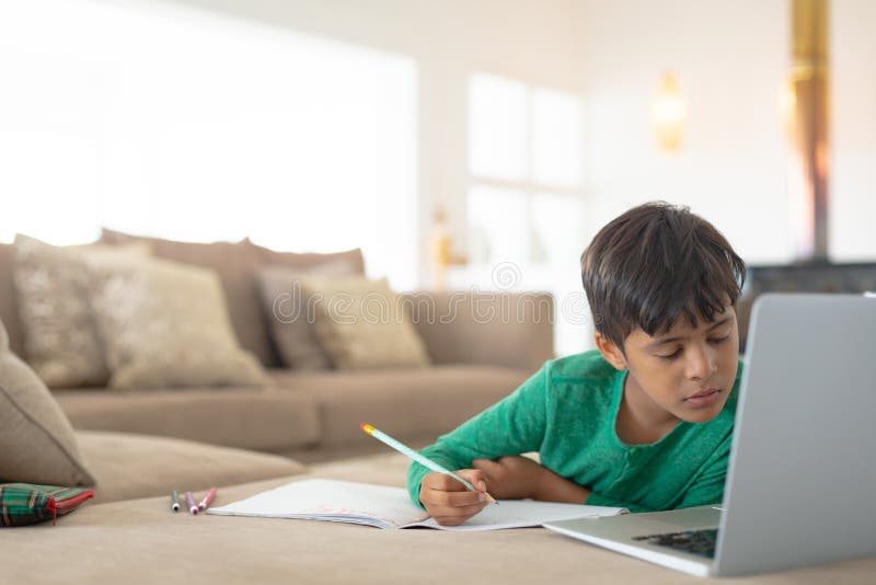 Boy Using Laptop while Drawing a Sketch on Book at Home Stock Image ...