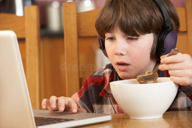 Boy Using Laptop Whilst Eating Breakfast Stock Photo - Image of home ...