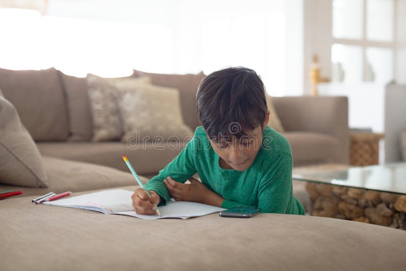 Boy Using Mobile Phone while Drawing a Sketch on Book at Home Stock ...