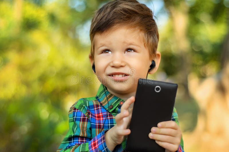 Boy Using Mobile Phone with Earphones Stock Image - Image of face, kids ...