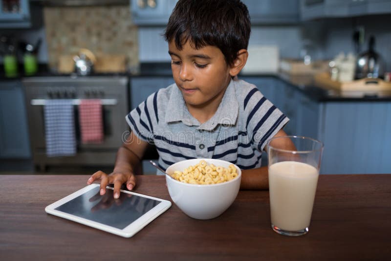 Boy Using Tablet Computer while Having Breakfast Stock Photo - Image of ...