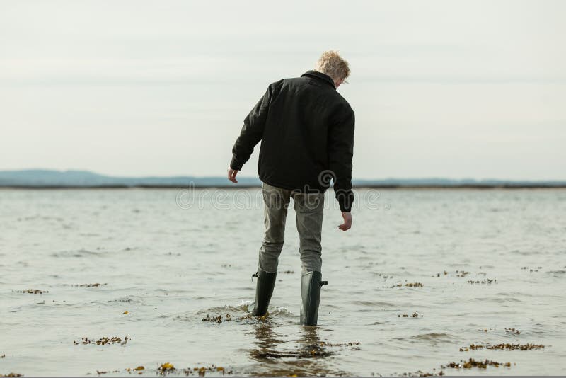 Boy Wading in Water Moving in during High Tide Stock Image - Image of ...