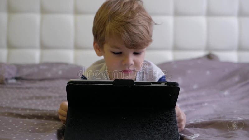 Boy Watching Tablet while Lying on Bed Stock Footage - Video of smiling ...