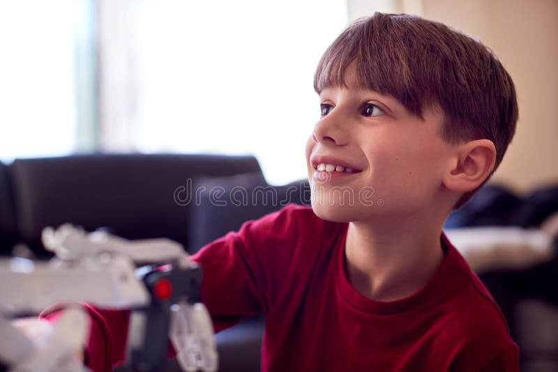 Boy Wearing Pyjamas Building Robotic Arm from Plastic Kit at Home Stock ...