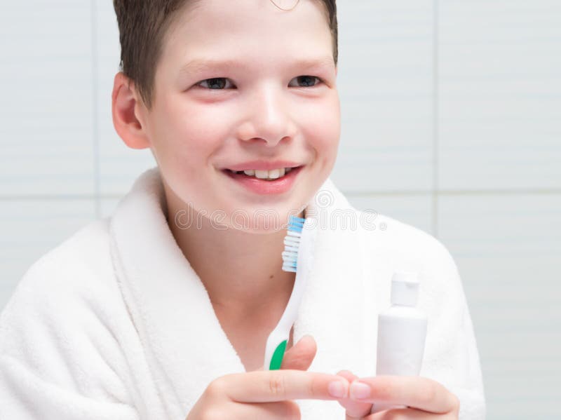 Boy, in a White Coat, in the Bathroom, Holds a Toothbrush and ...