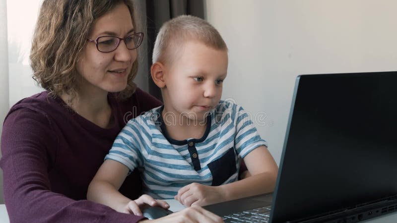 Boy Working on a Computer Together with His Mom at Home. E-lessons ...