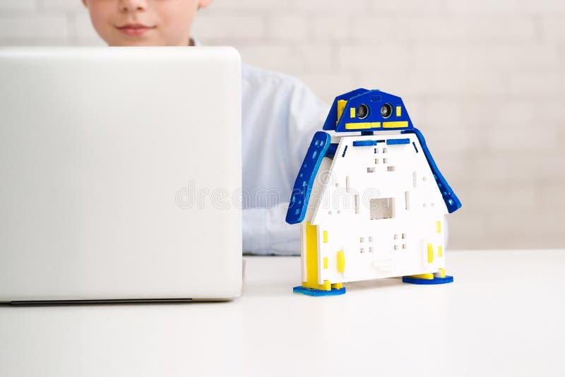 Boy Working on Laptop with a Toy Robot beside Them Stock Photo - Image ... Boy Working on Laptop with a Toy Robot beside Them Stock Photo - Image ...