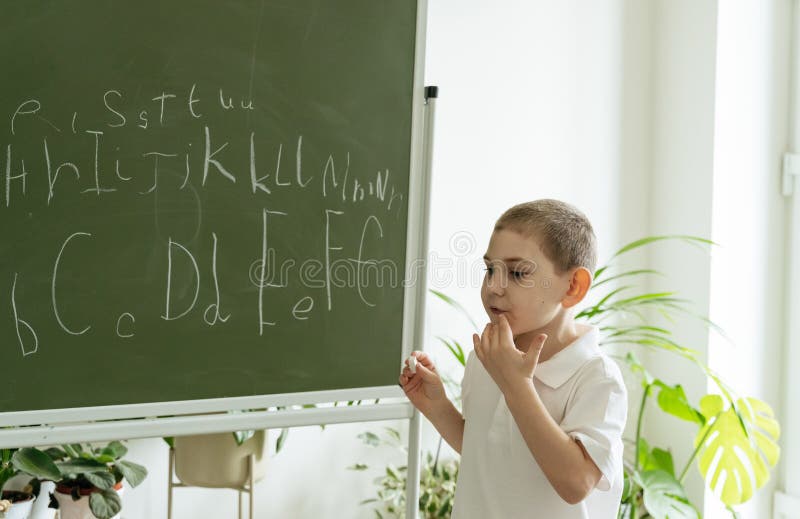Boy Writing Abc Letters on the Green Chalkboard Stock Photo - Image of ...