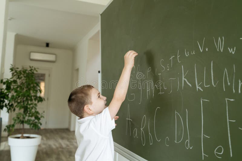 Boy Writing Abc Letters on the Green Chalkboard Stock Image - Image of ...