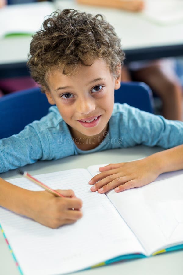 Boy writing on book stock photo. Image of lesson, classroom - 77704260