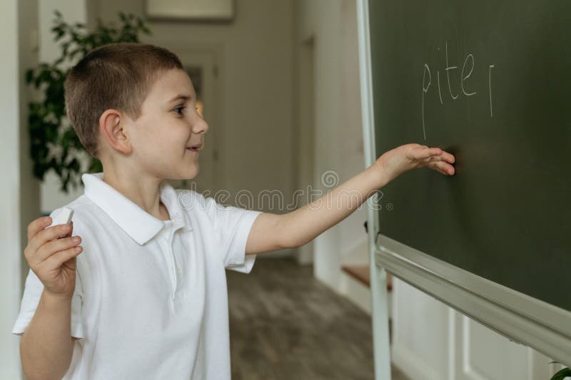 Boy Writing His Name on the Green Chalkboard Stock Photo - Image of ...