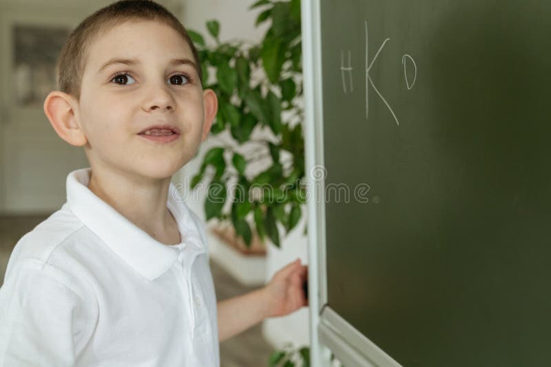 Boy Writing His Name on the Green Chalkboard Stock Photo - Image of ...