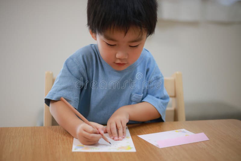 Boy writing a letter stock image. Image of indoors, pencils - 248725093