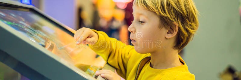 The Boy in the Yellow Jacket Uses a Touch Screen BANNER, LONG FORMAT ...